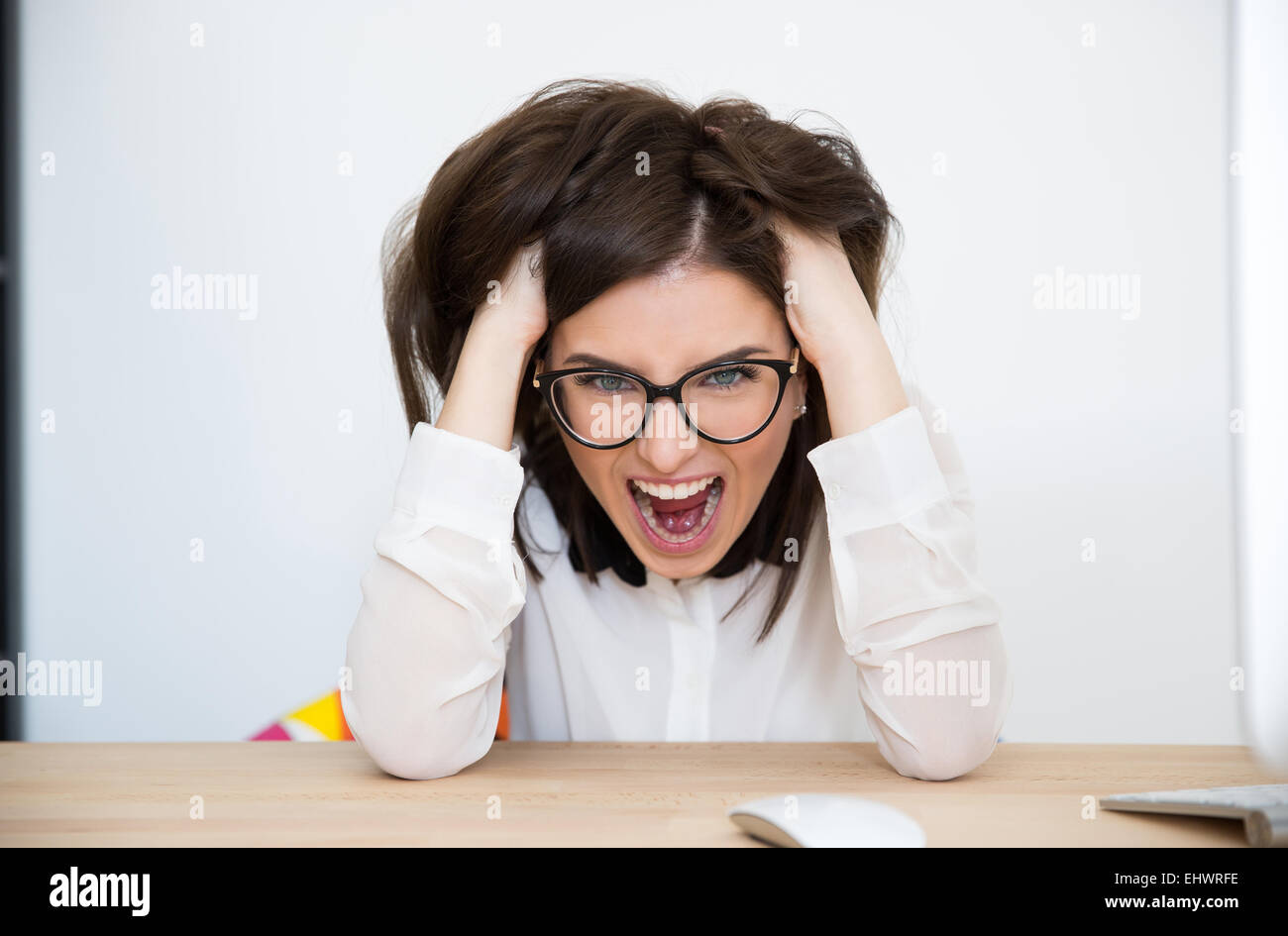 Angry businesswoman sitting at the table and yelling Stock Photo - Alamy