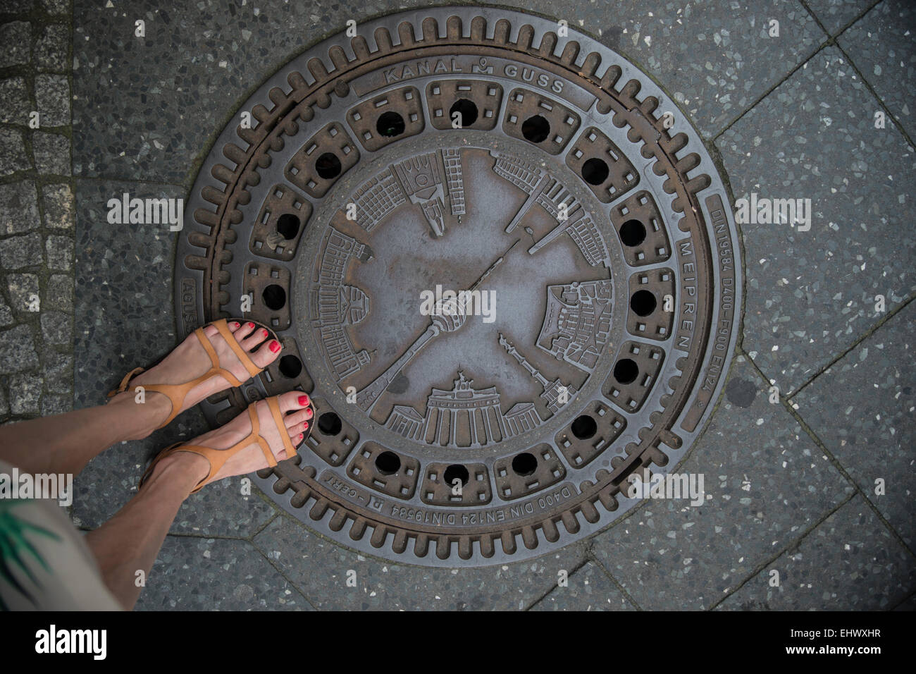 Germany, Berlin, woman's feet standing on manhole cover Stock Photo - Alamy