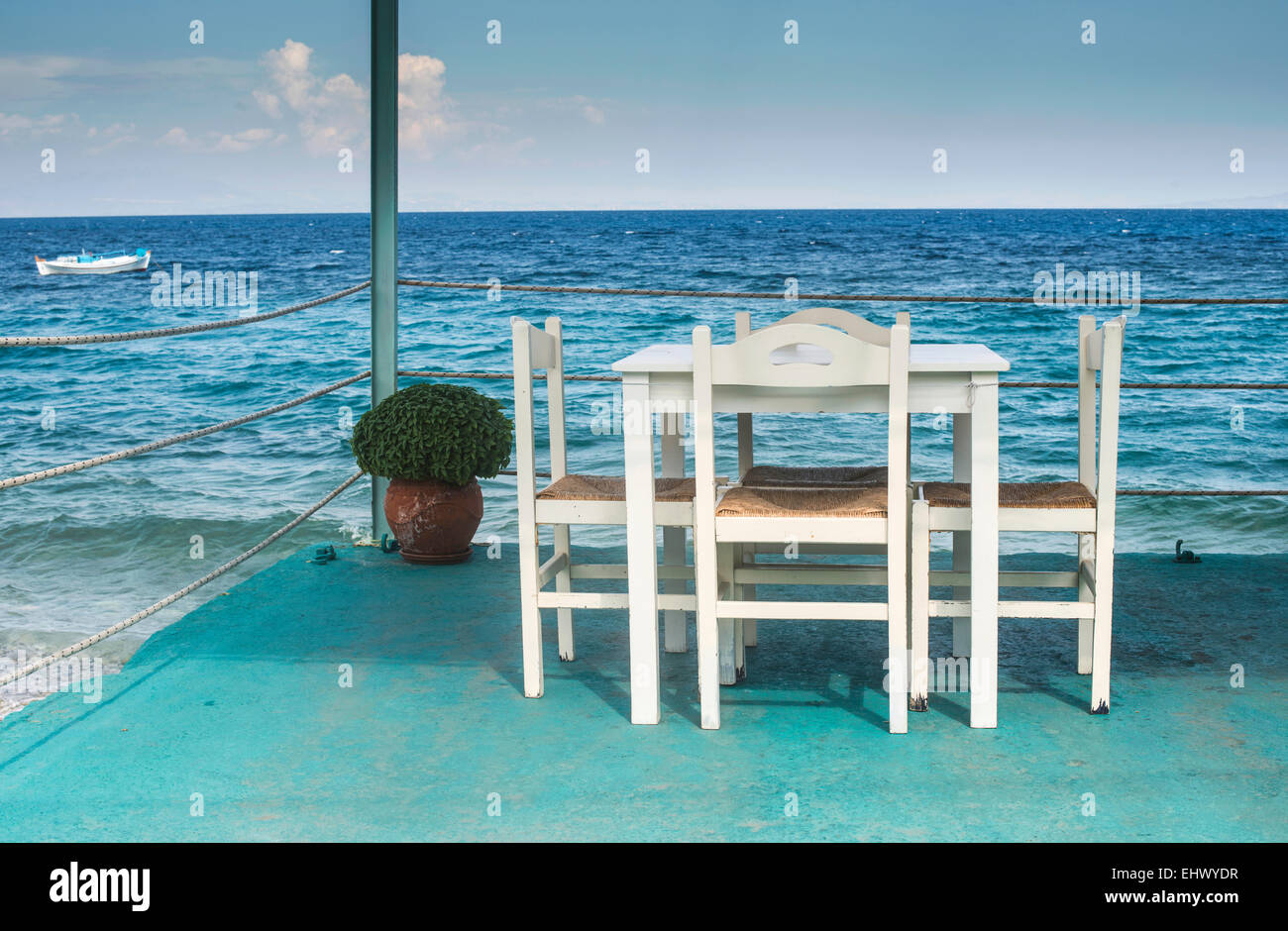 Greece, table and chairs of taverna with view to the sea Stock Photo ...