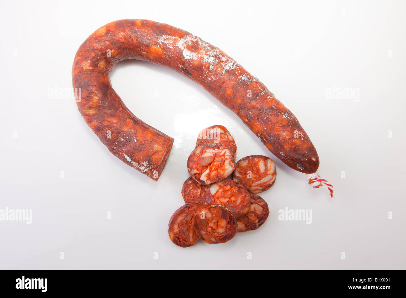 Red iberian chorizo with some cut pieces. Isolated over white ...