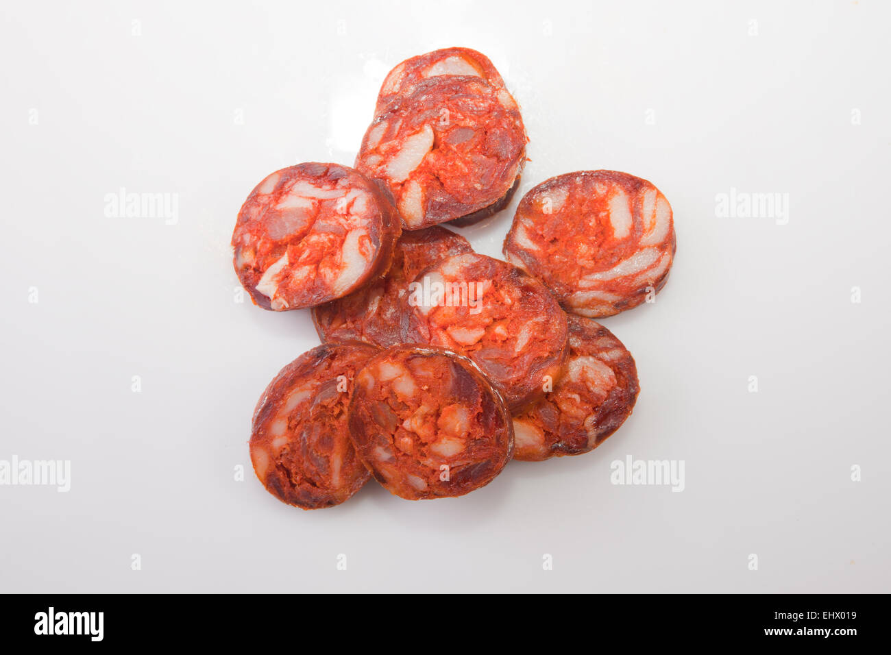 Some cut pieces of red iberian chorizo. Isolated over white background ...