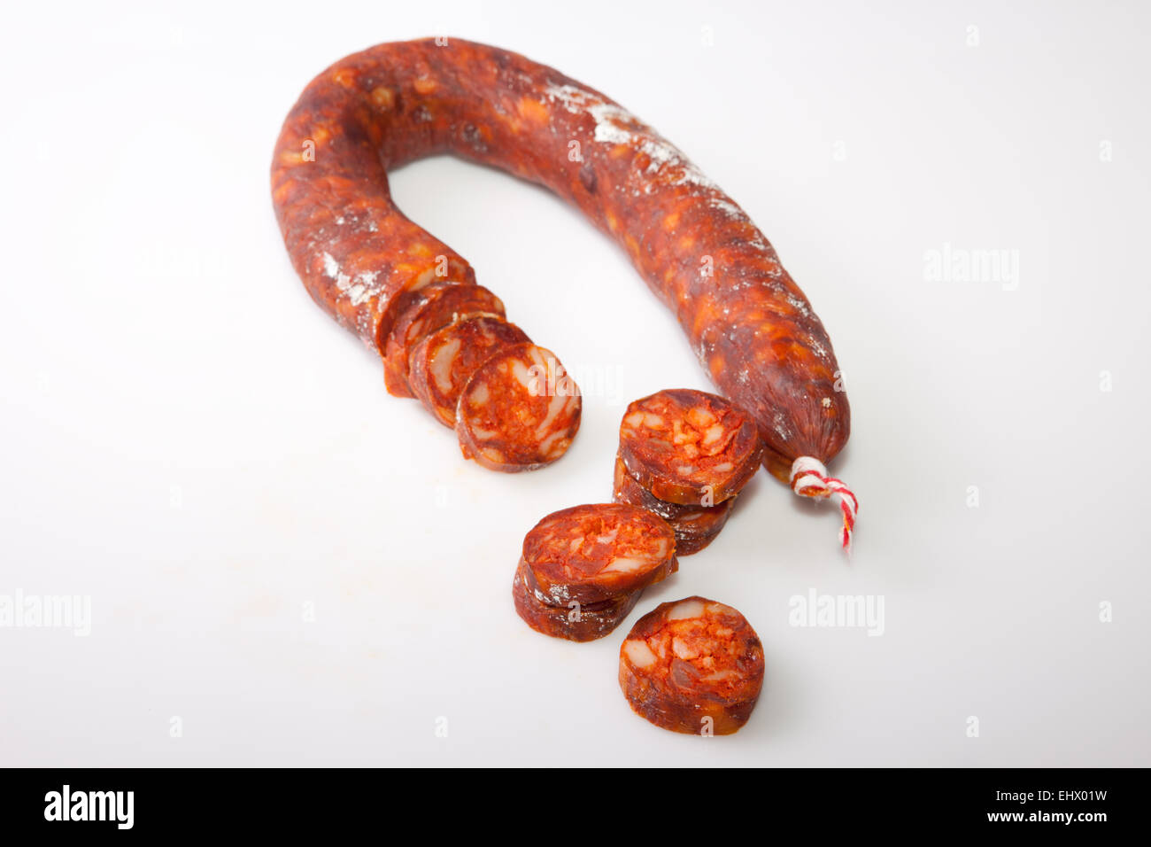 Red iberian chorizo with some cut pieces. Isolated over white ...