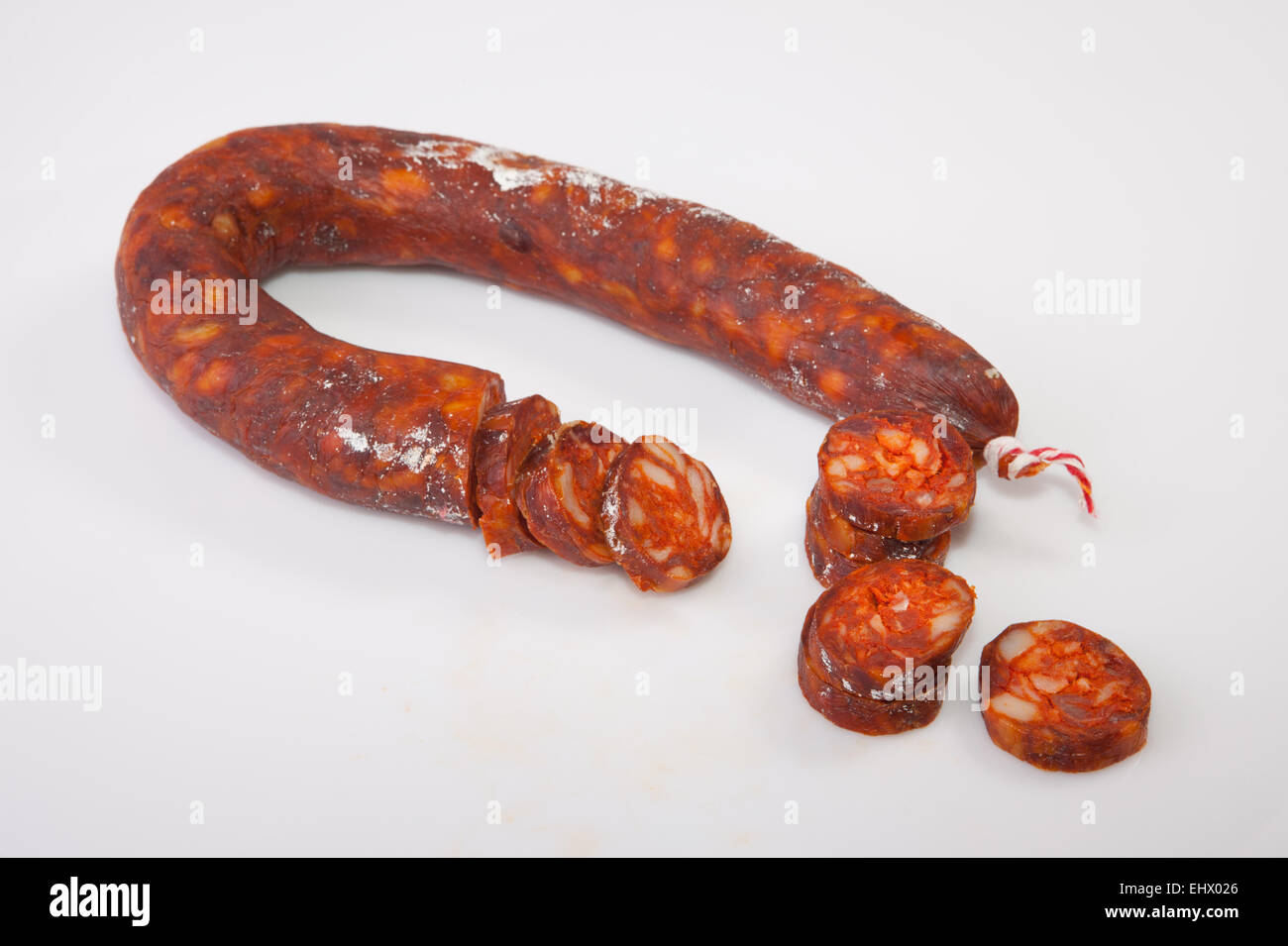 Red iberian chorizo with some cut pieces. Isolated over white ...