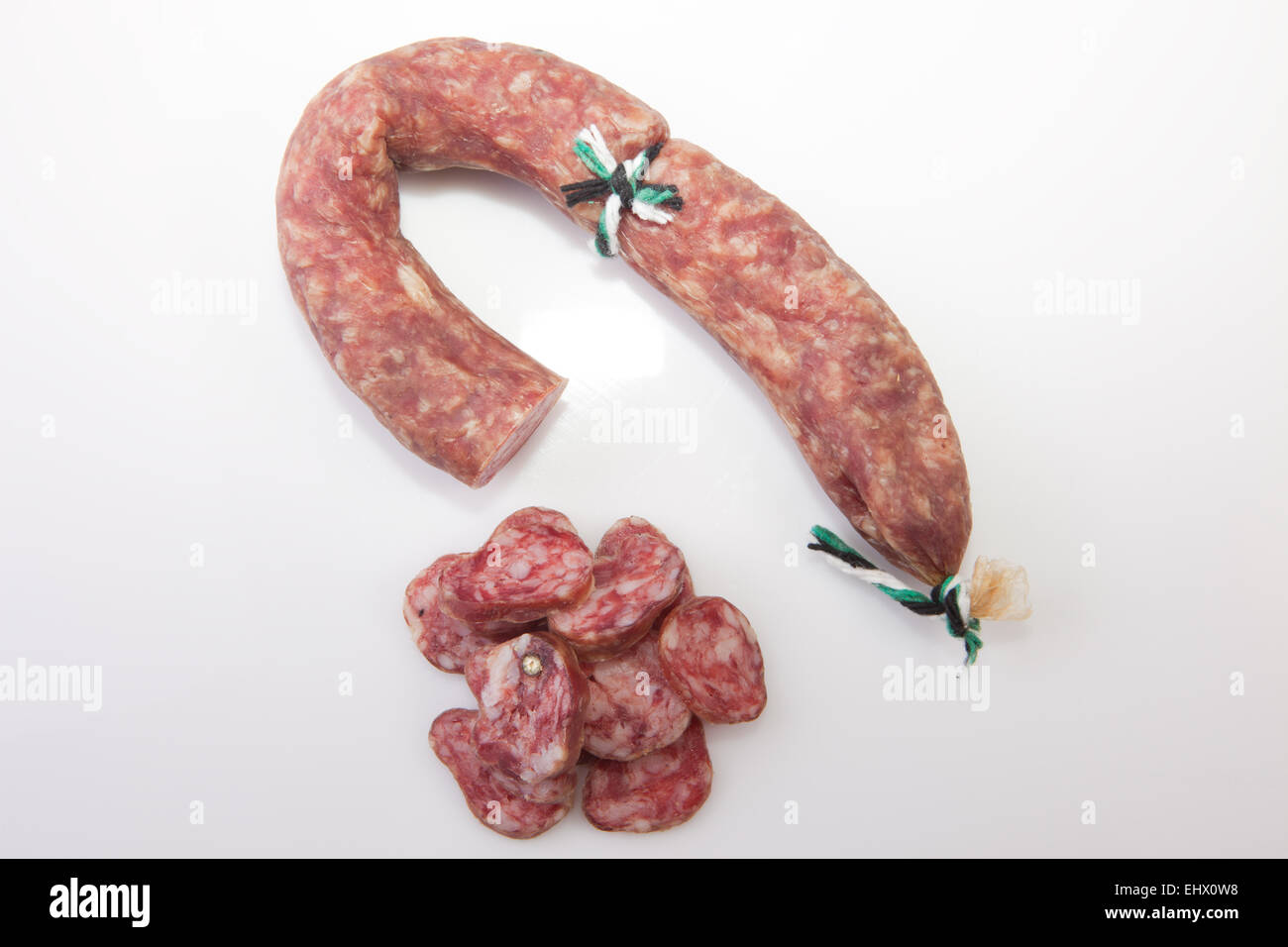 Cured spicy sausage with some cut pieces. Isolated over with background ...