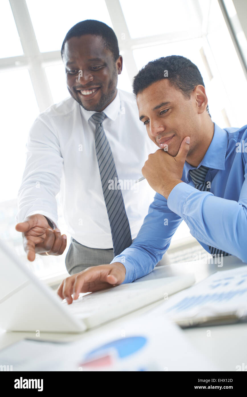 Male colleagues discussing their cooperative work Stock Photo - Alamy