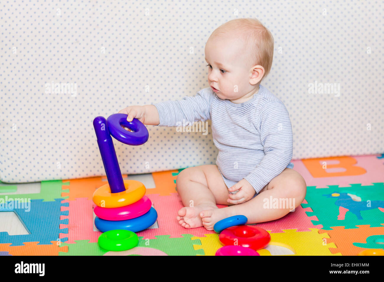 Cute little baby playing with colorful toys at home Stock Photo - Alamy
