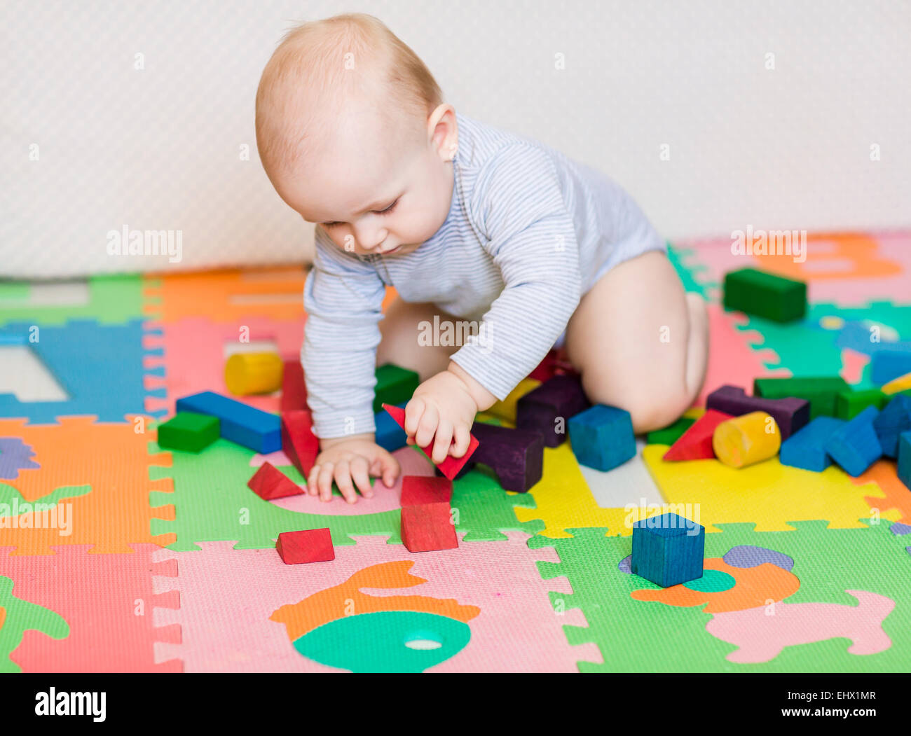 Cute little baby playing with colorful toys at home Stock Photo - Alamy