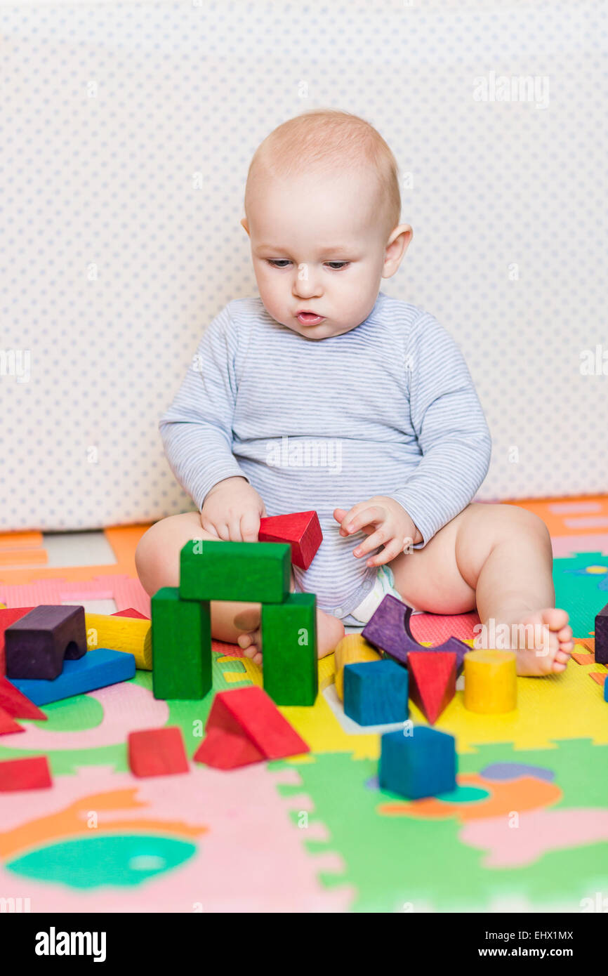 Cute little baby playing with colorful toys at home Stock Photo - Alamy
