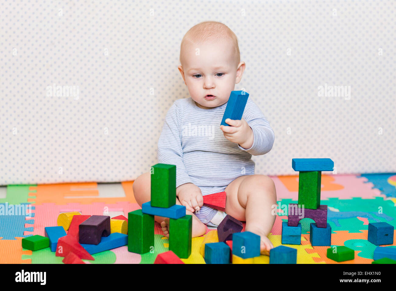 Cute little baby playing with colorful toys at home Stock Photo - Alamy