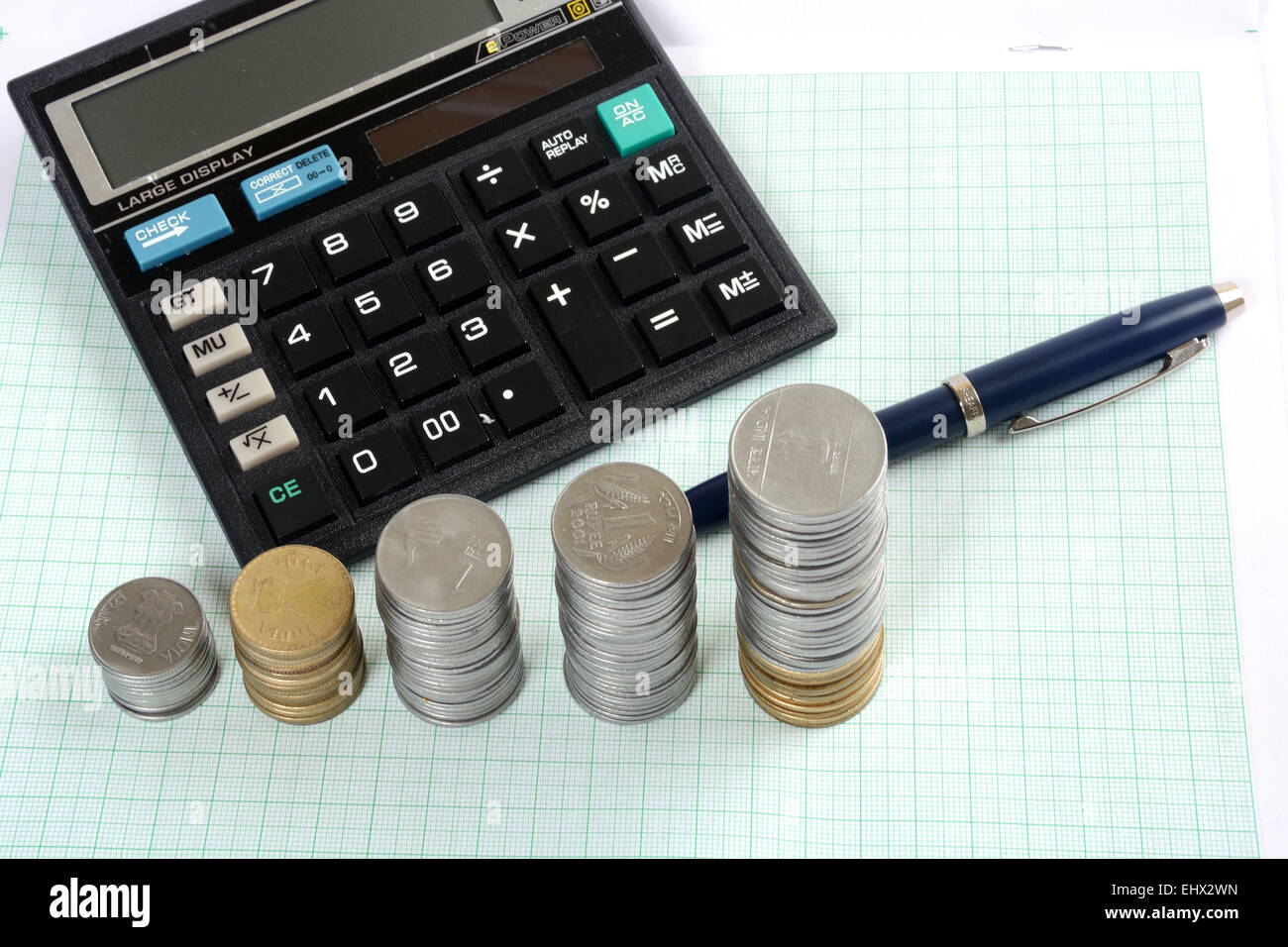 Pen and calculator with coins Stock Photo - Alamy
