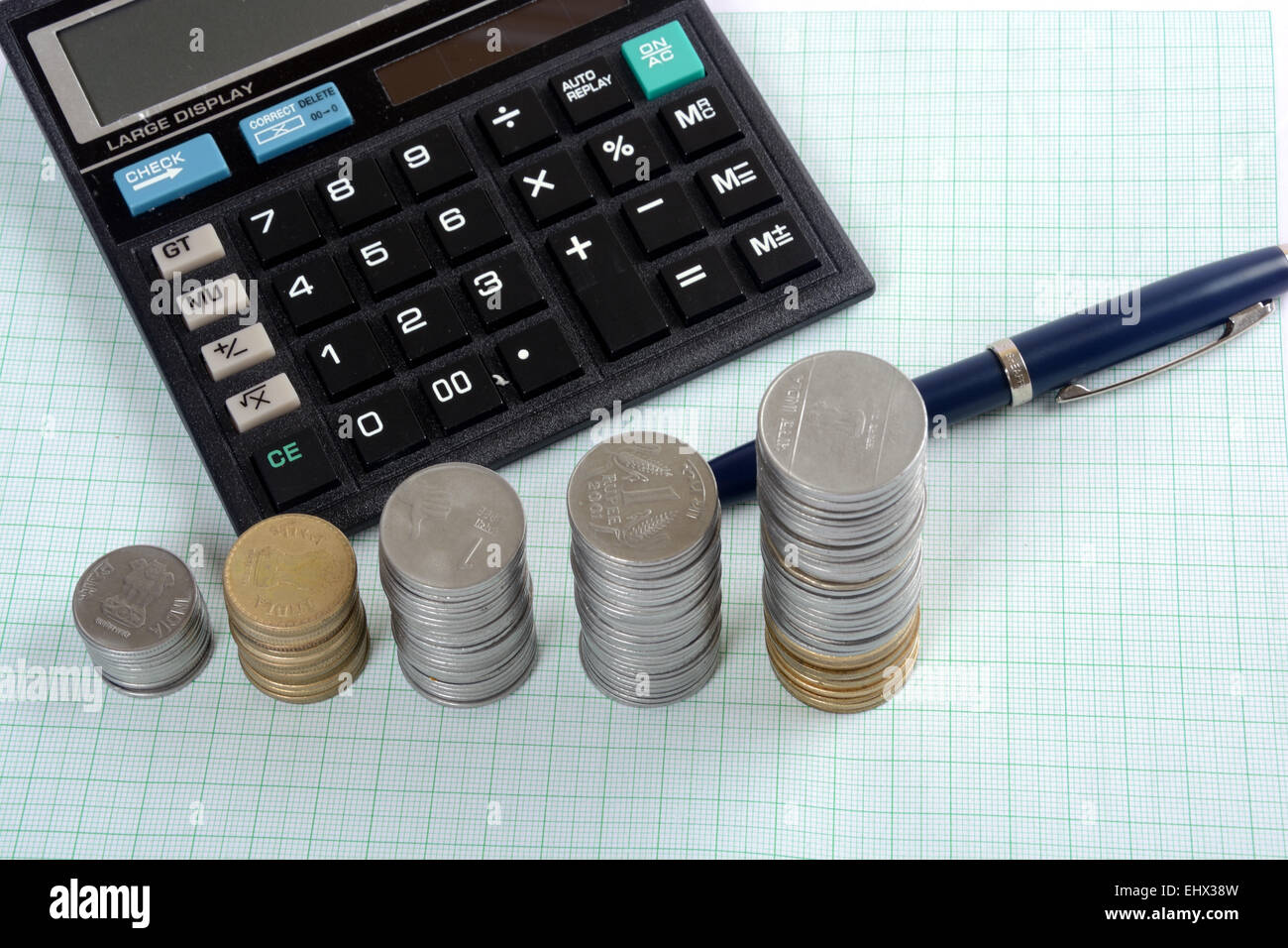 Pen and calculator with coins Stock Photo - Alamy