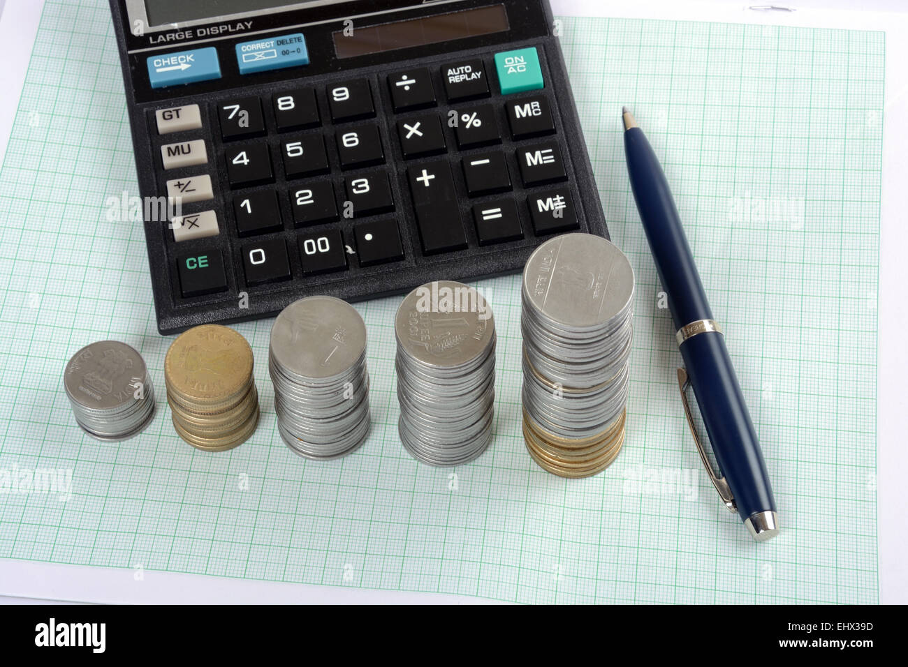 Pen and calculator with coins Stock Photo - Alamy