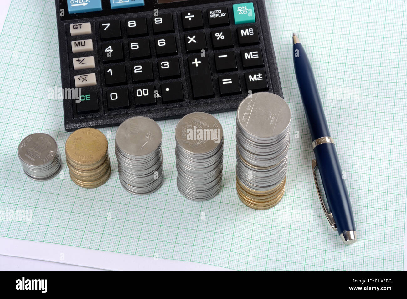 Pen and calculator with coins Stock Photo - Alamy
