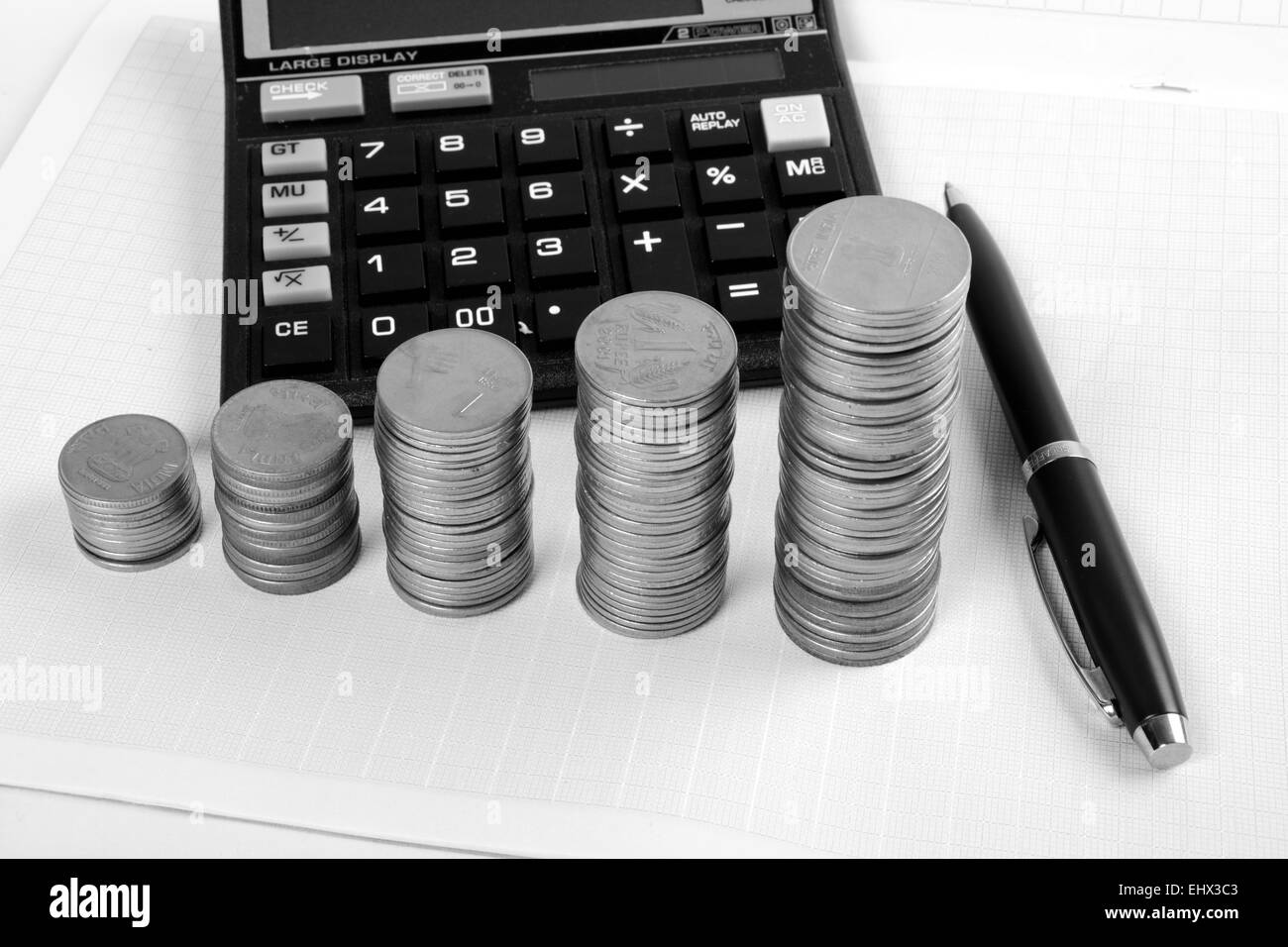 Pen and calculator with coins Stock Photo - Alamy