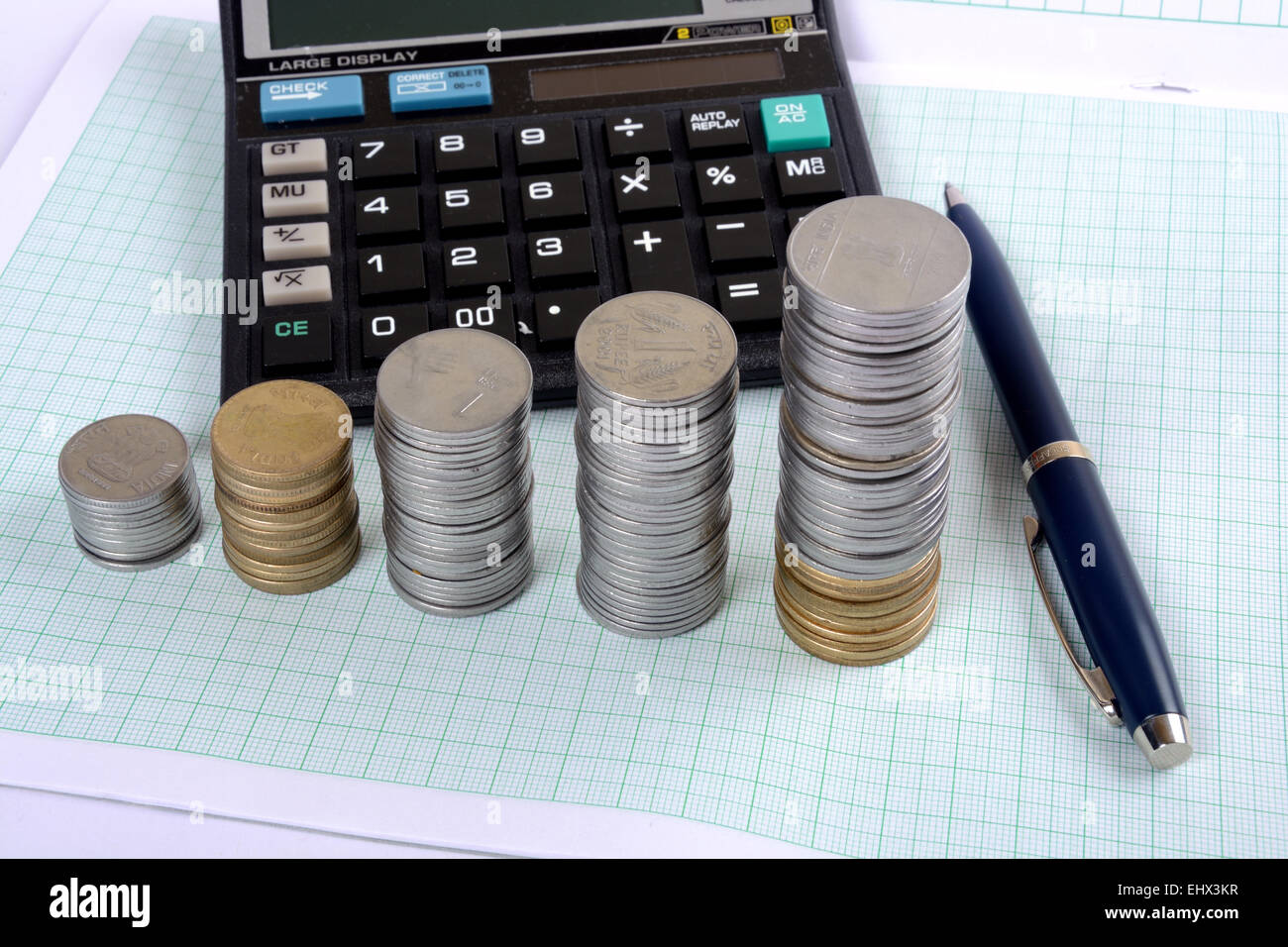 Pen and calculator with coins Stock Photo - Alamy