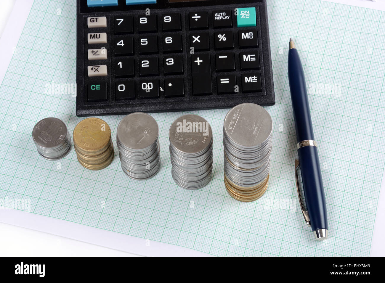 Pen and calculator with coins Stock Photo - Alamy