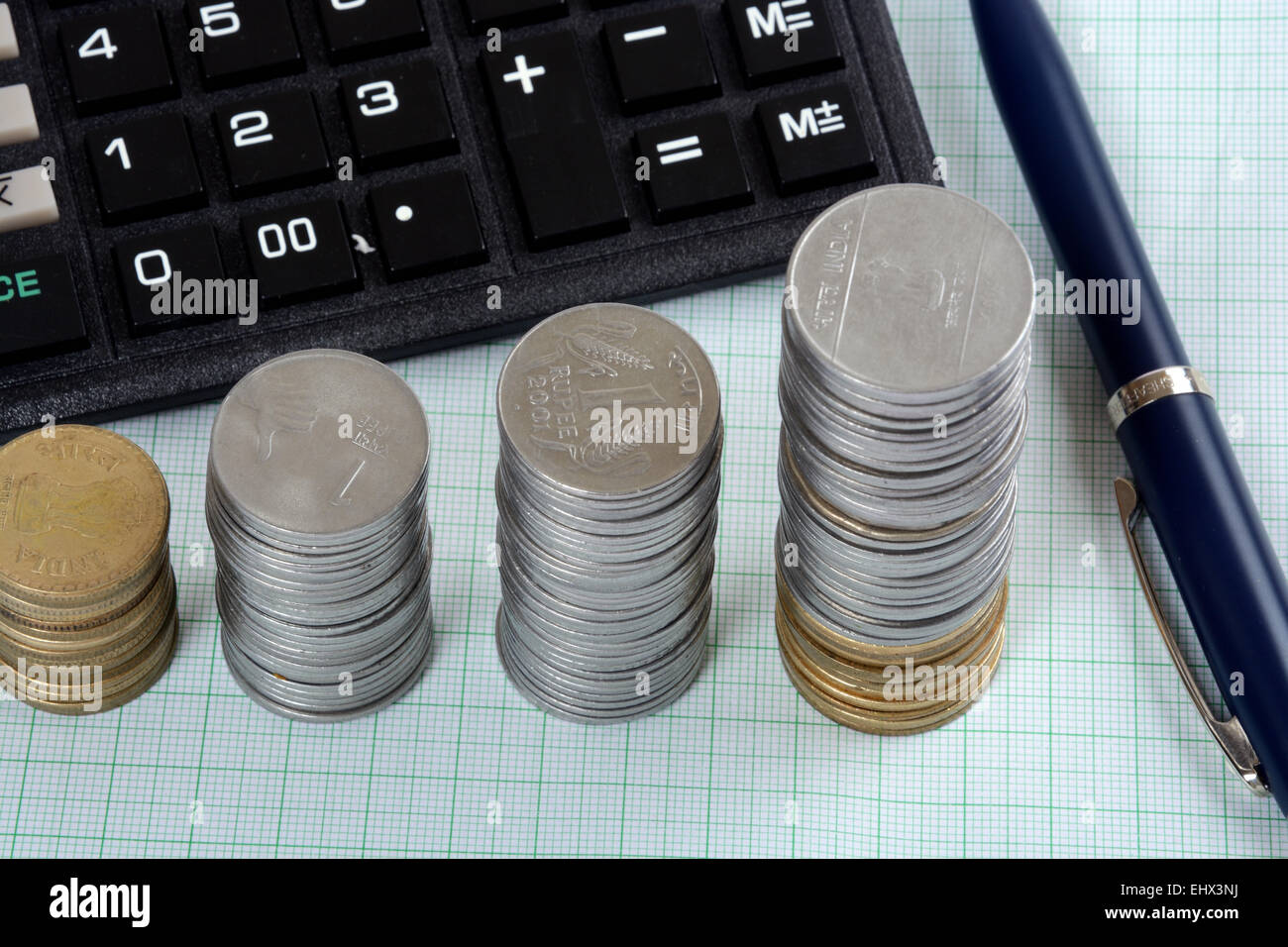 Pen and calculator with coins Stock Photo - Alamy