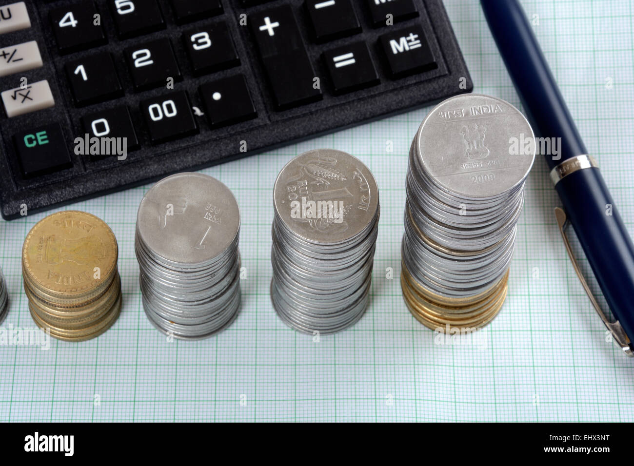 Pen and calculator with coins Stock Photo - Alamy