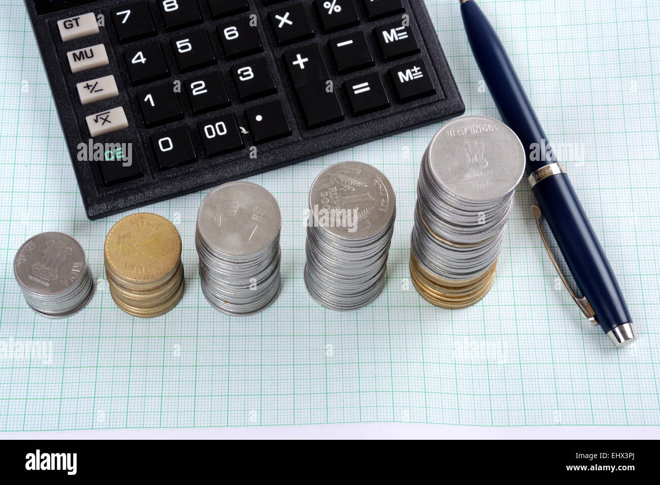 Pen and calculator with coins Stock Photo - Alamy