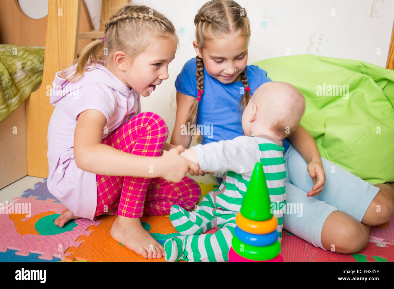 Happy kids playing with little brother in the room Stock Photo - Alamy