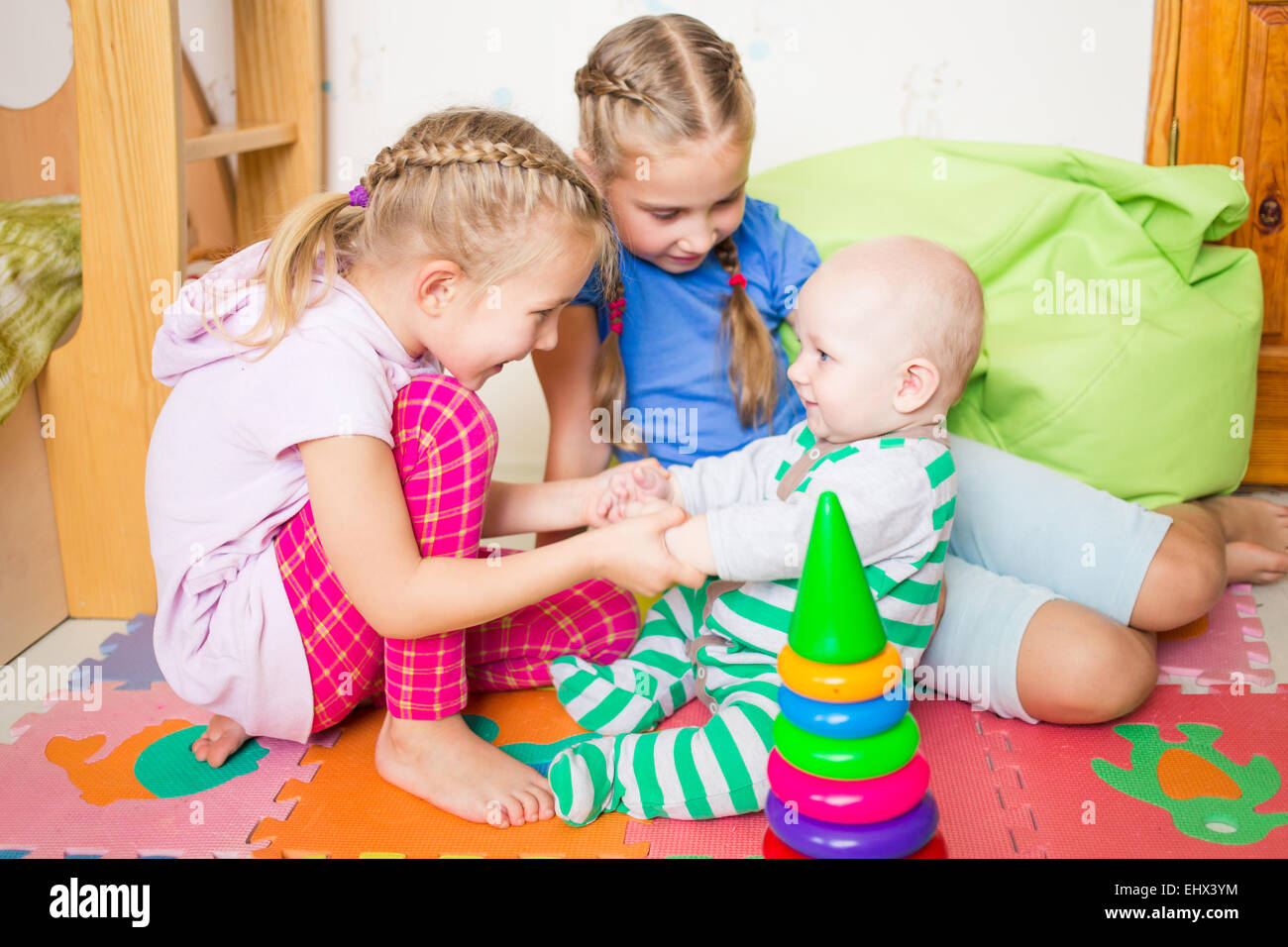 Happy kids playing with little brother in the room Stock Photo - Alamy