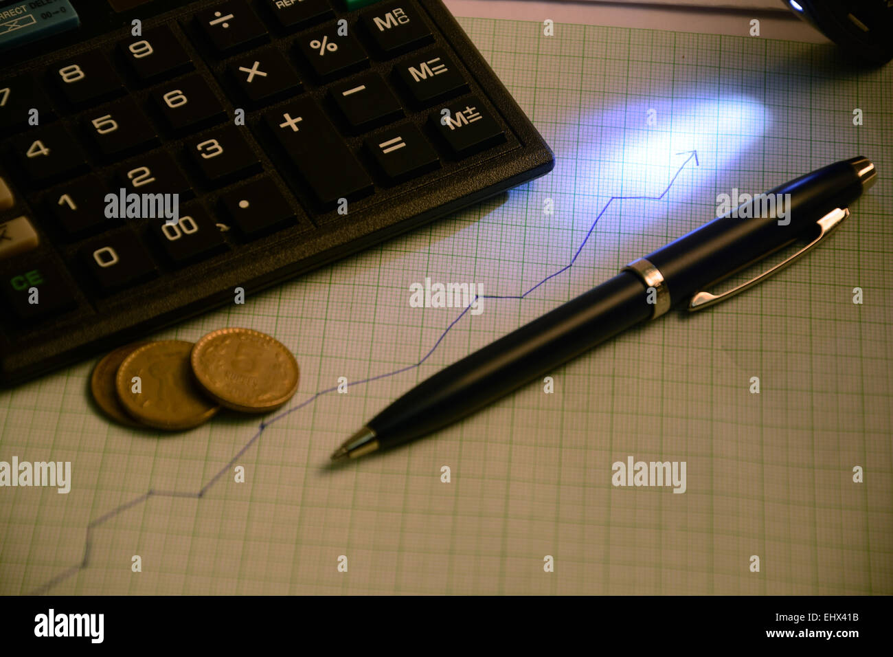 Pen and calculator with coins Stock Photo - Alamy