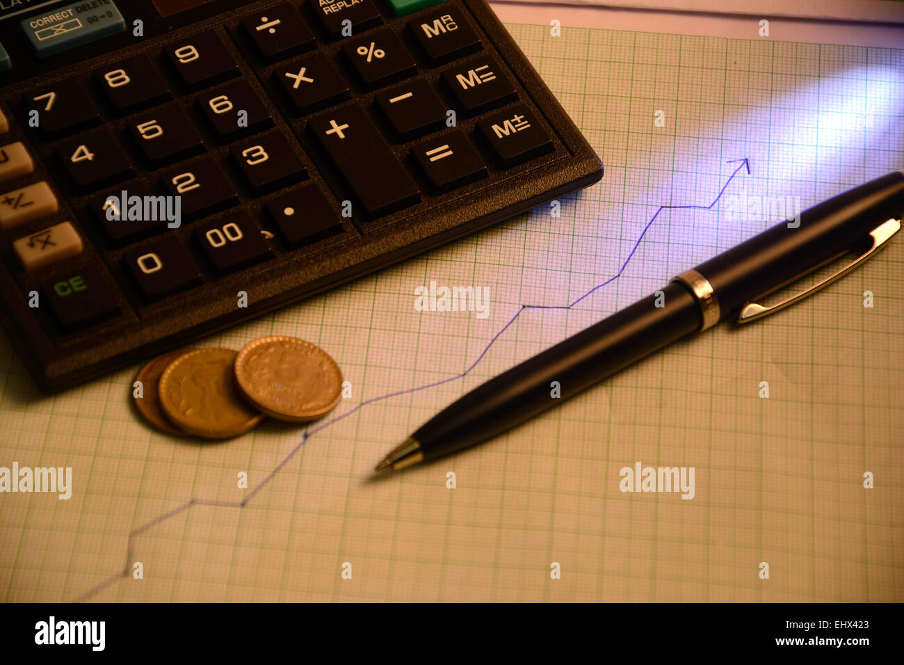 Pen and calculator with coins Stock Photo - Alamy
