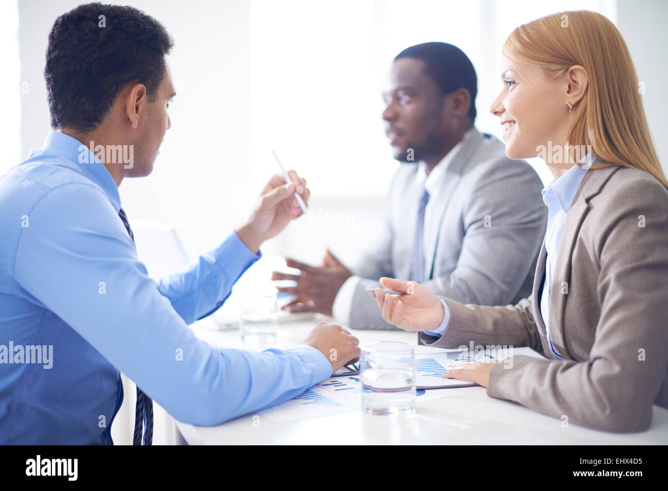 Three colleagues talking at briefing Stock Photo - Alamy