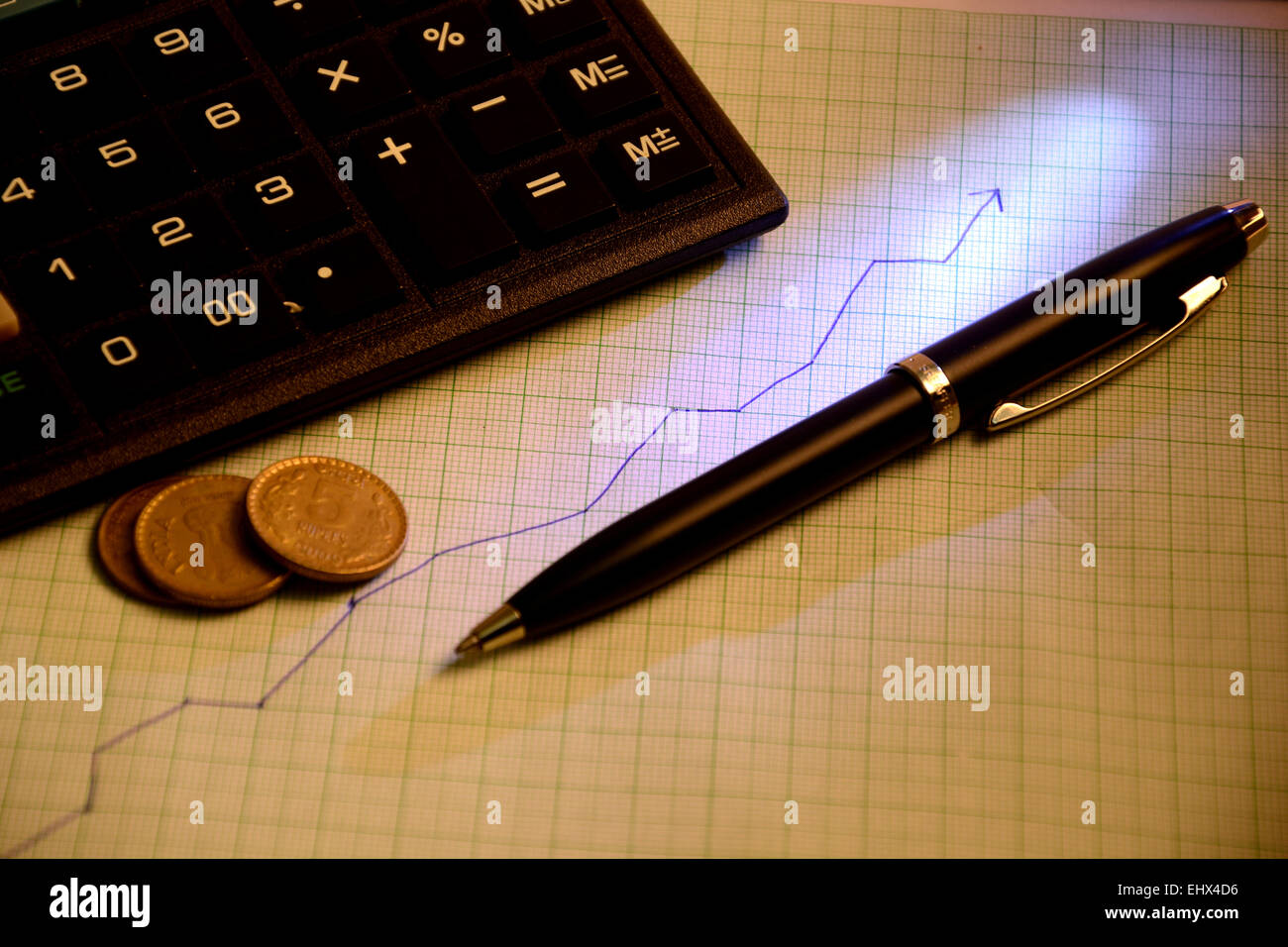 Pen and calculator with coins Stock Photo - Alamy