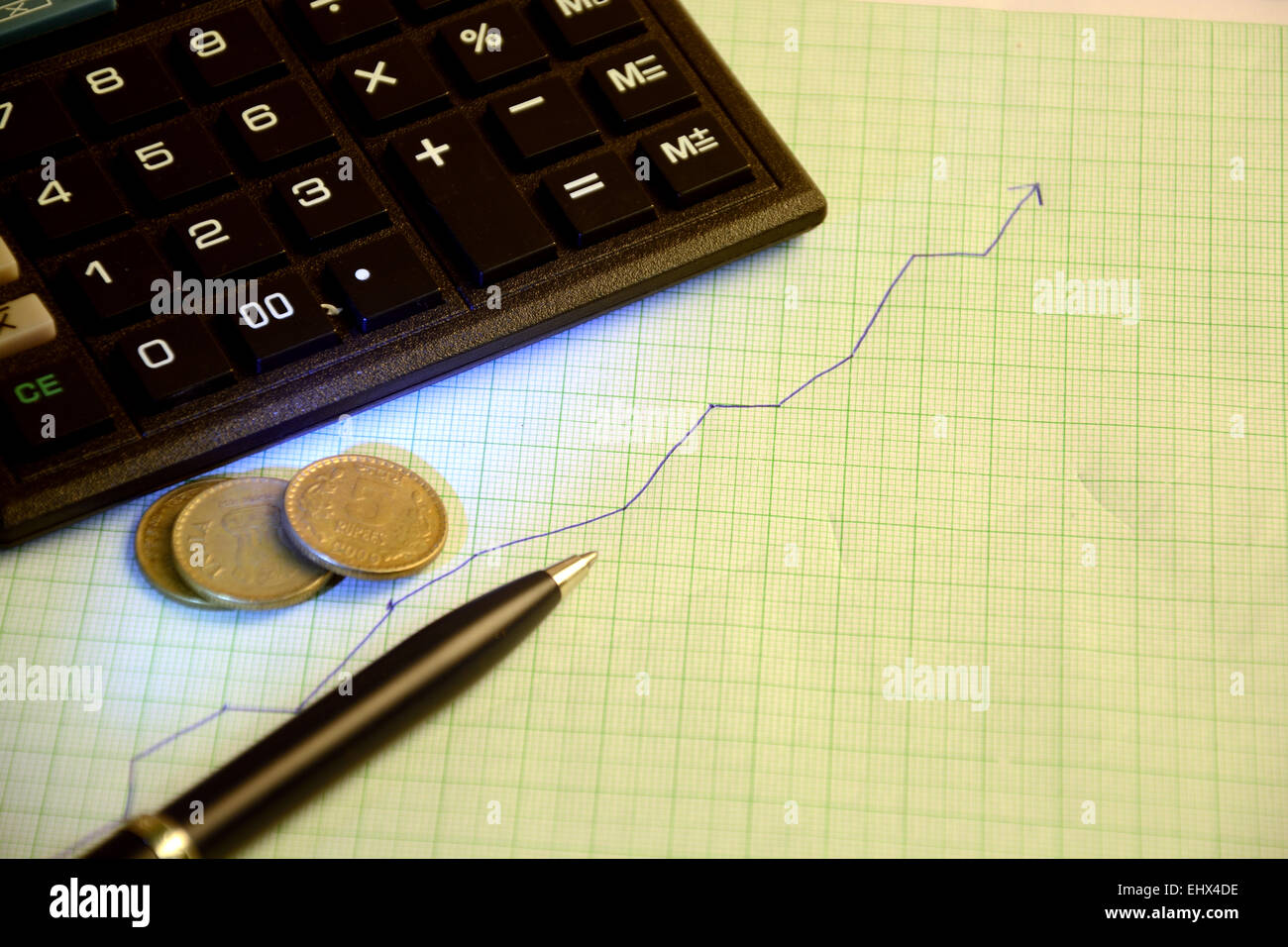 Pen and calculator with coins Stock Photo - Alamy