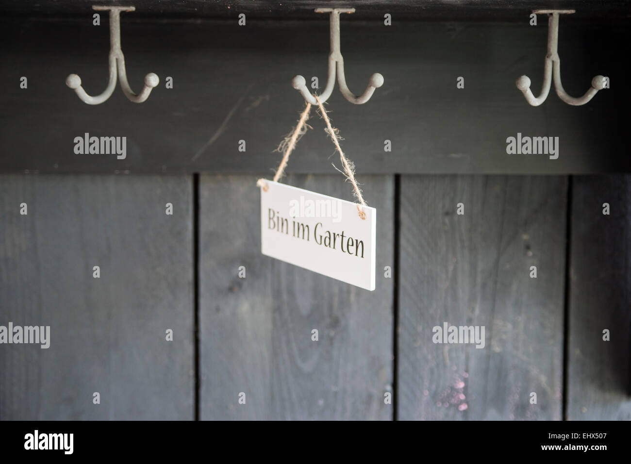 Sign hanging on coat rack Stock Photo - Alamy