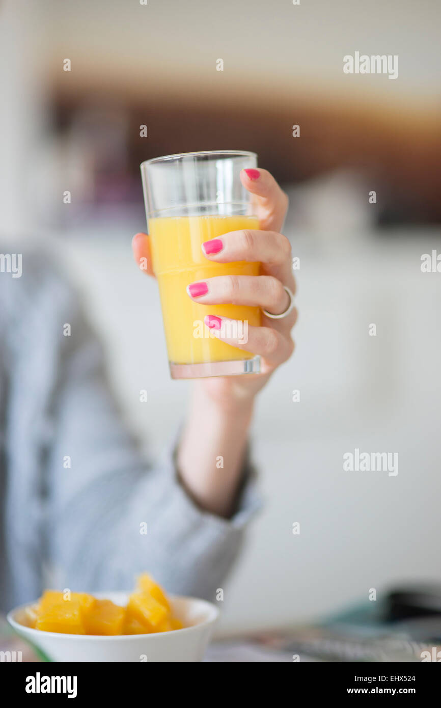 Woman's hand holding glass of orange juice Stock Photo - Alamy