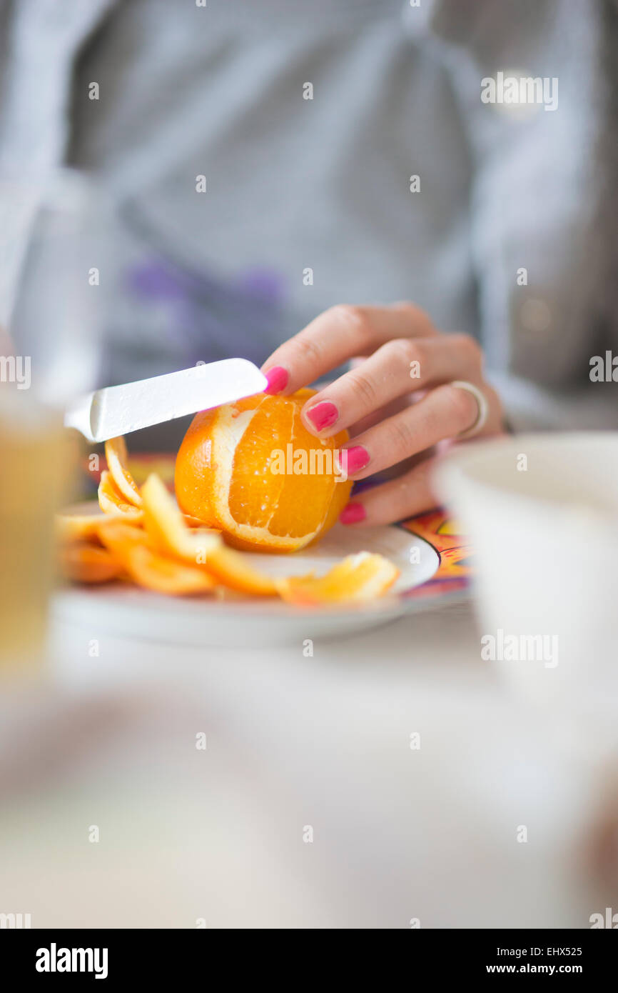 Woman peeling orange Stock Photo - Alamy