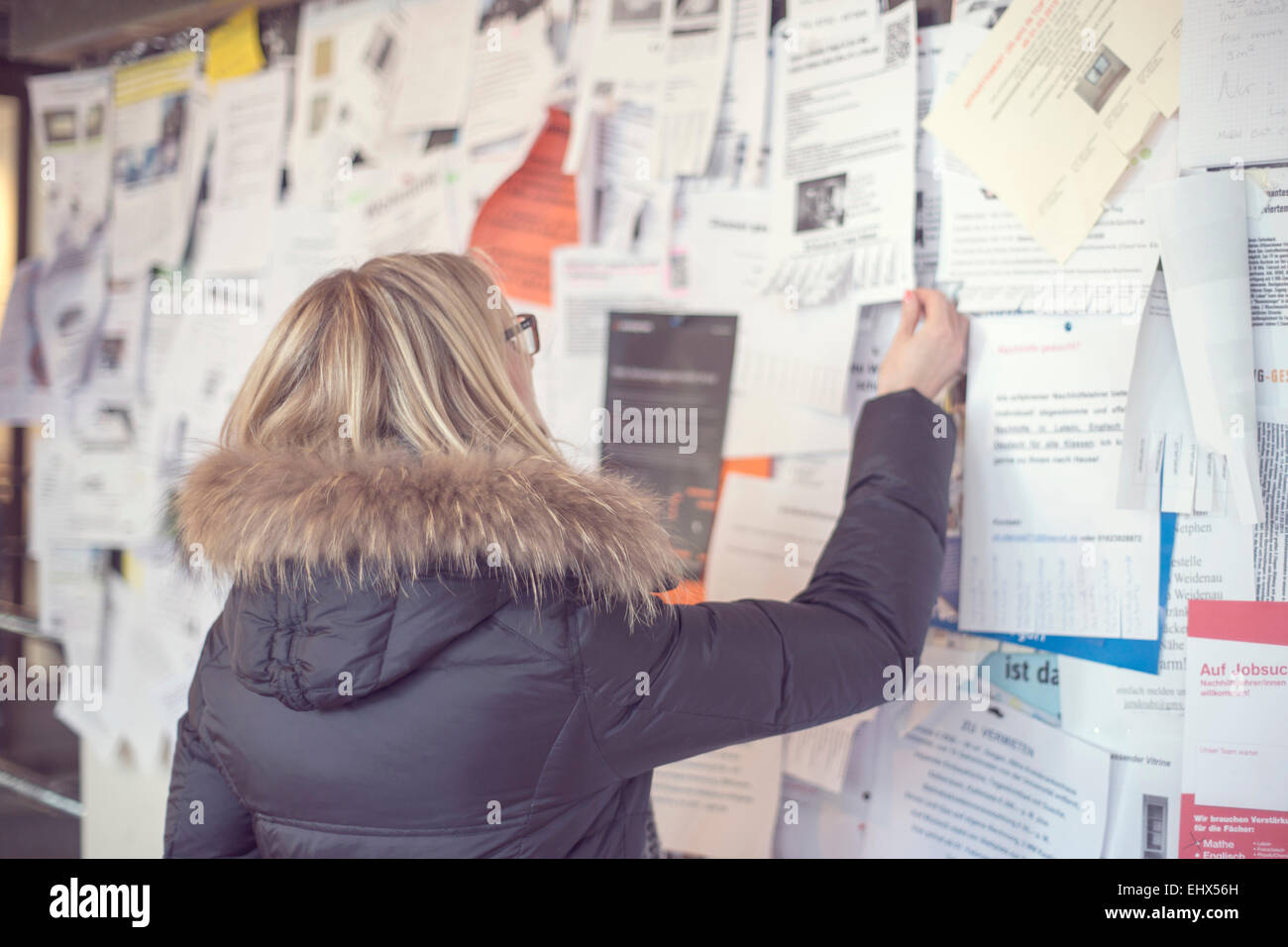 Woman reading at notice board Stock Photo - Alamy