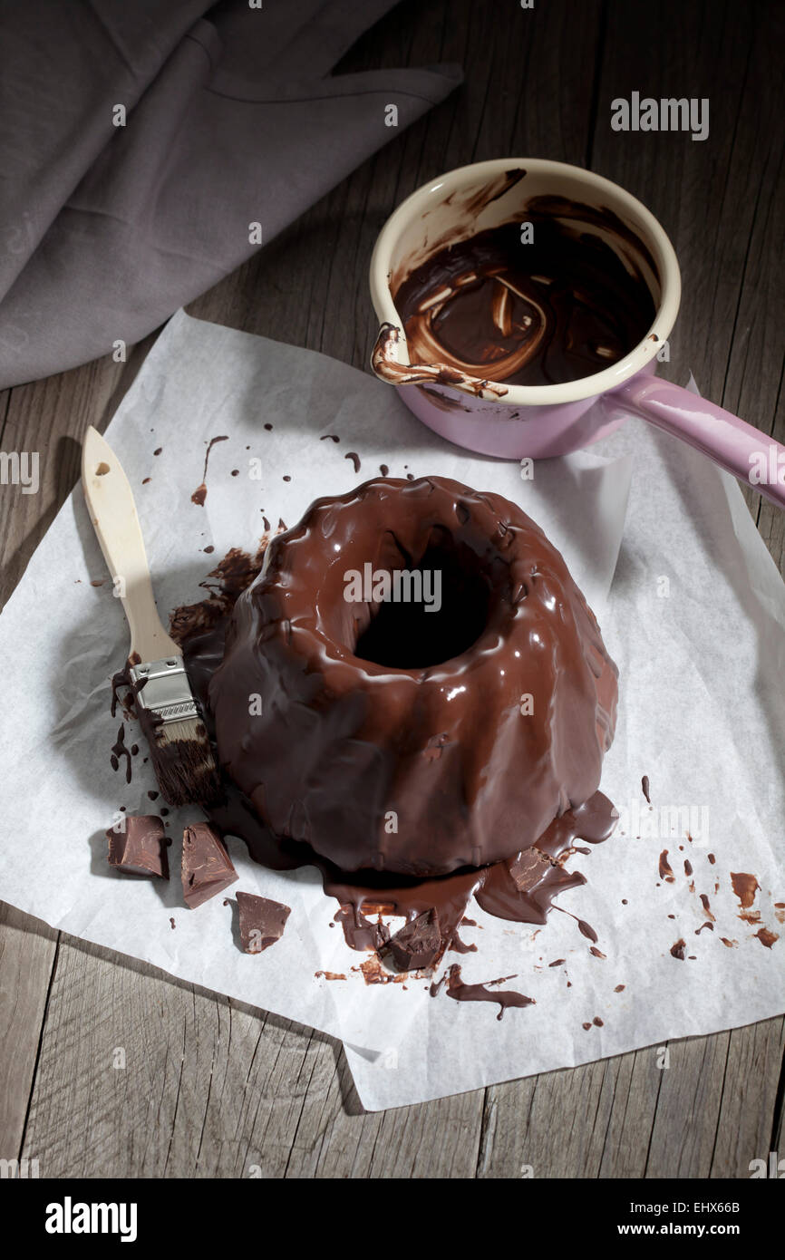 Marble cake, chocolate icing, pot and knife on greaseproof paper Stock ...