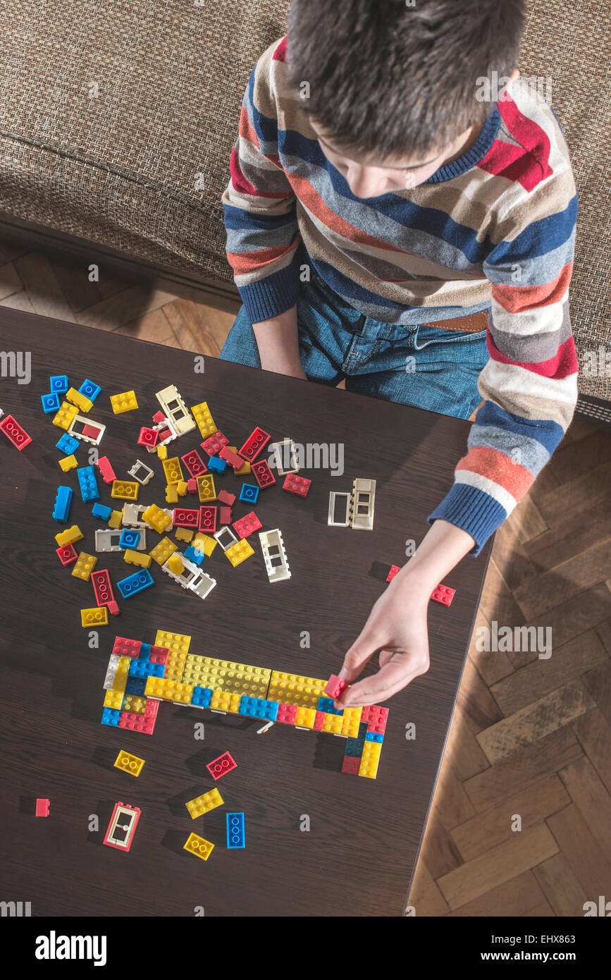 Boy playing with building bricks on a table Stock Photo - Alamy