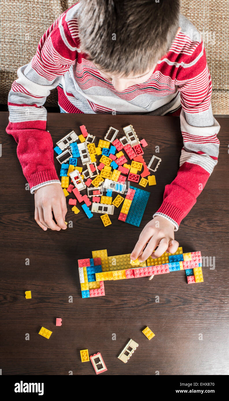 Boy playing with building bricks on a table Stock Photo - Alamy