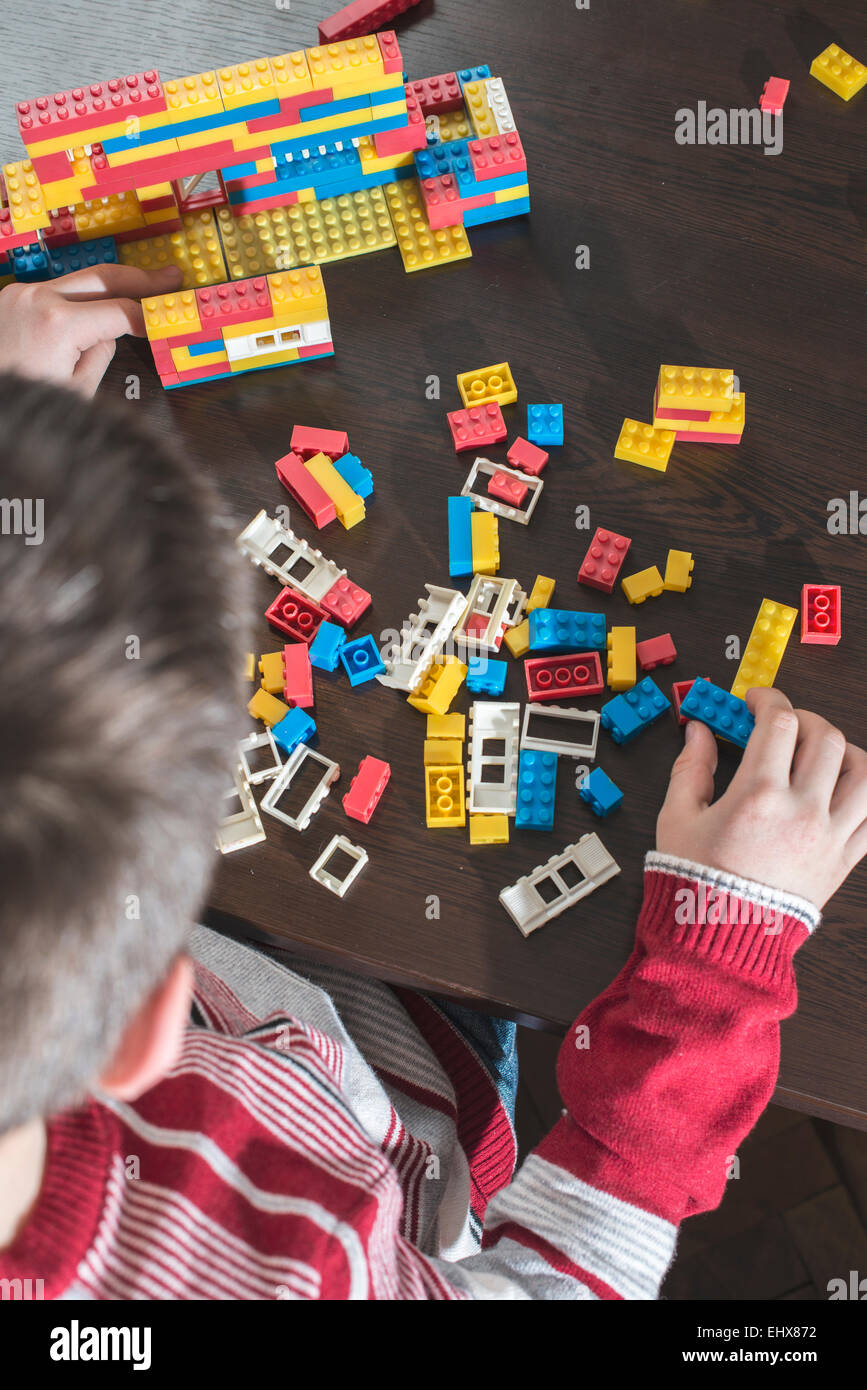 Boy playing with building bricks on a table Stock Photo - Alamy
