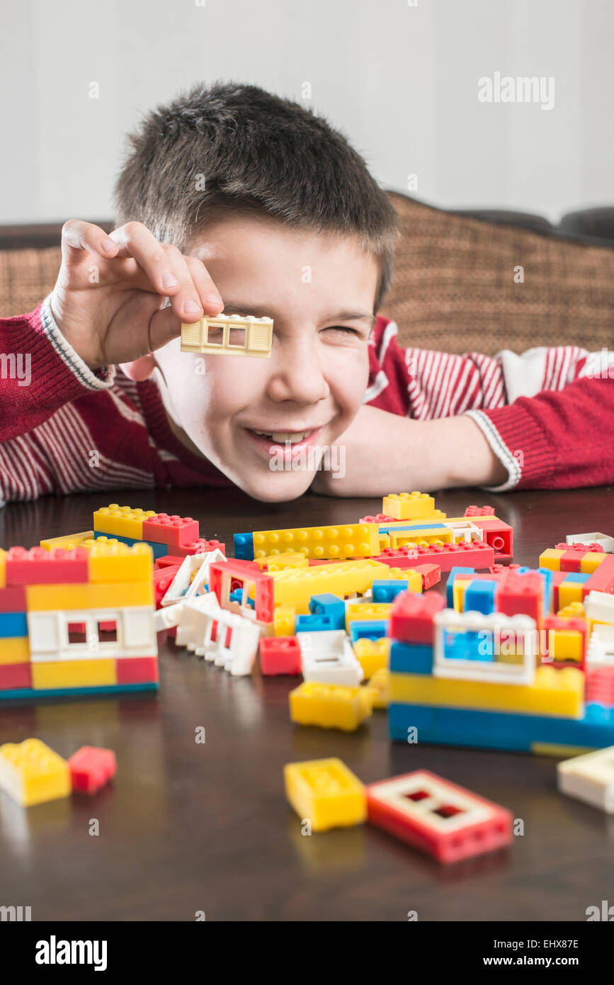 Boy playing with building bricks on a table Stock Photo - Alamy