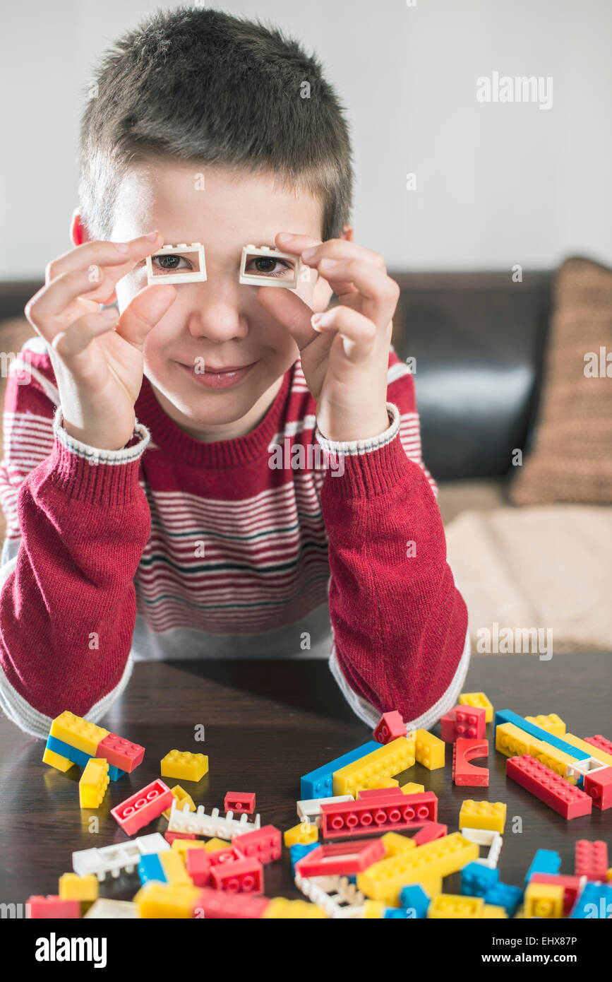 Boy playing with building bricks on a table Stock Photo - Alamy