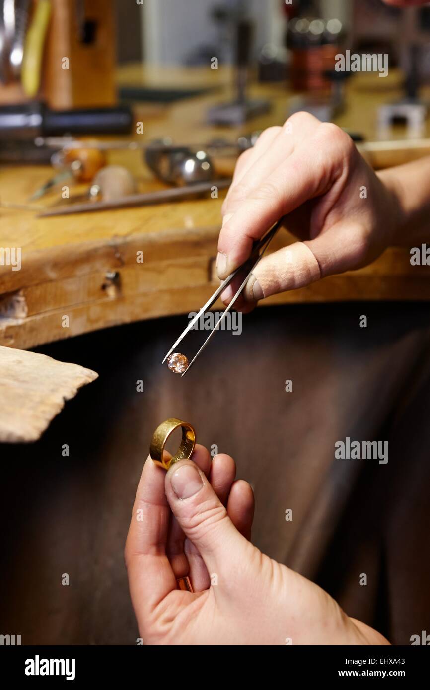 Goldsmith in workshop with gemstone and golden ring Stock Photo - Alamy