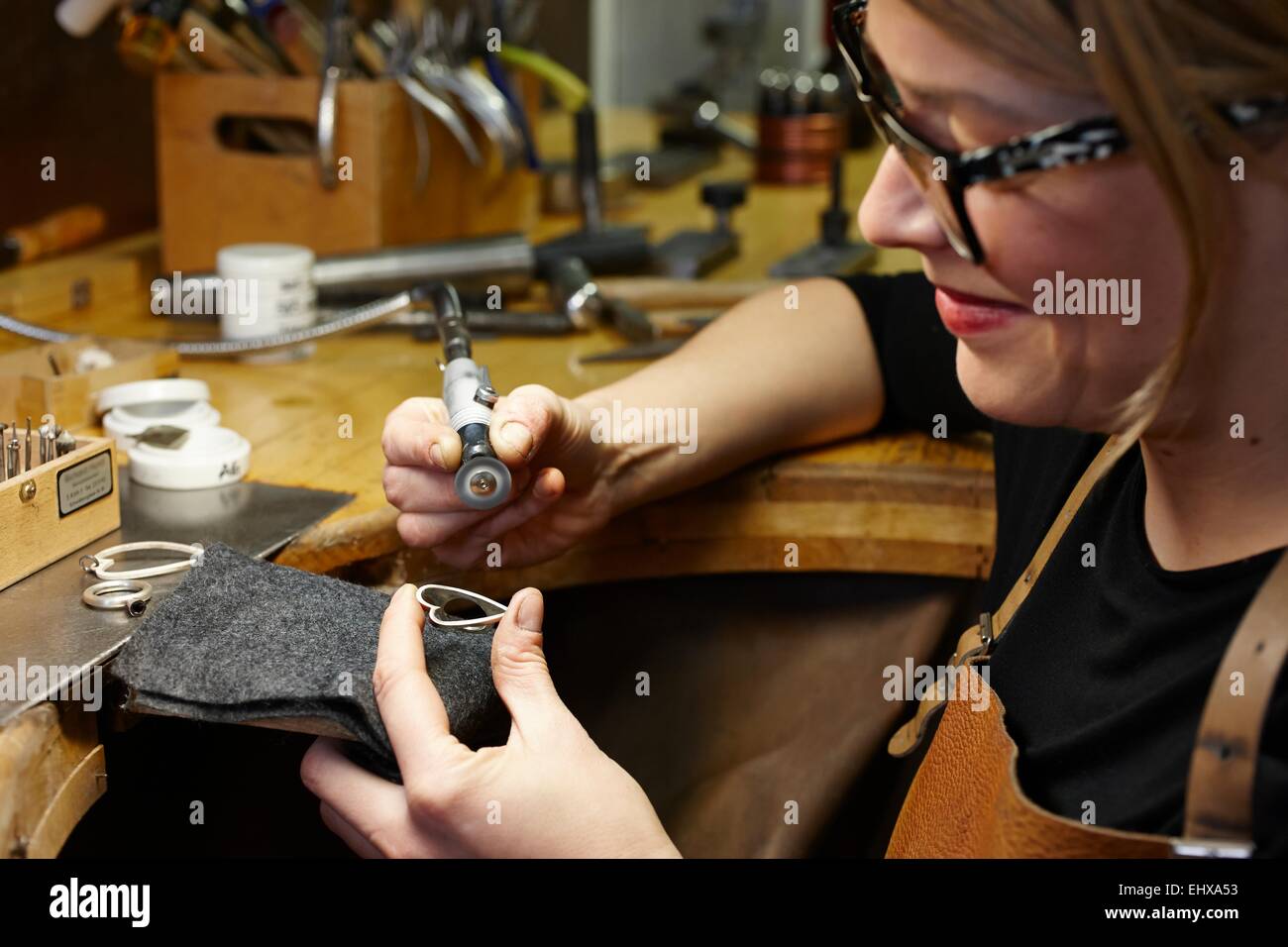 Goldsmith in workshop working on heart-shaped piece of jewelry Stock ...