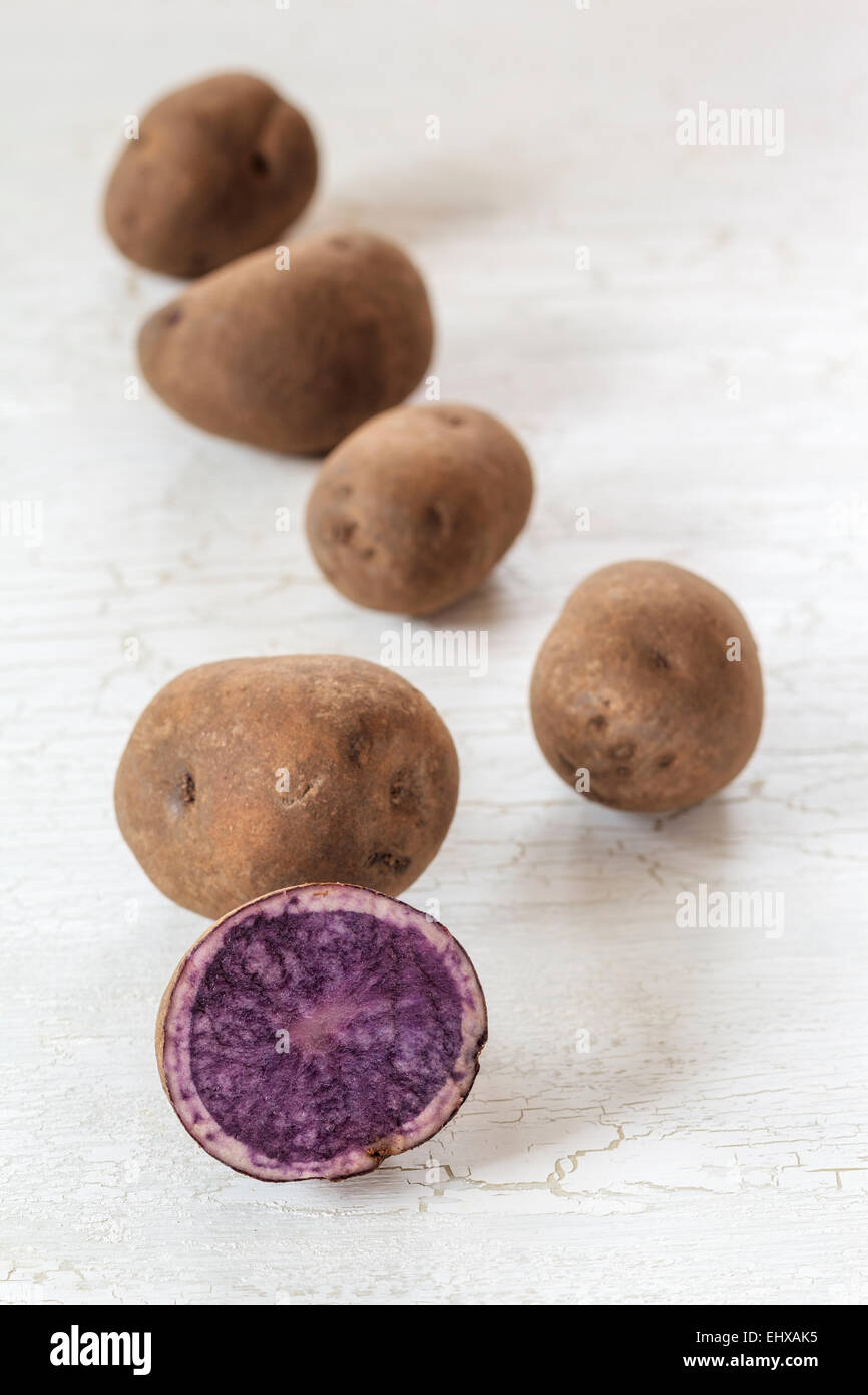 Sliced and whole raw Blue Congo potatoes Stock Photo - Alamy