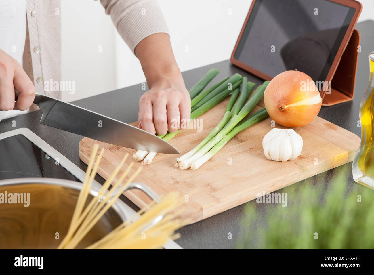 Woman cutting spring onions in the kitchen Stock Photo - Alamy