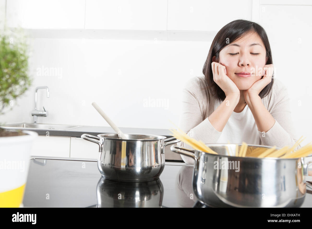 Portrait of smiling young woman relaxing while cooking Stock Photo - Alamy