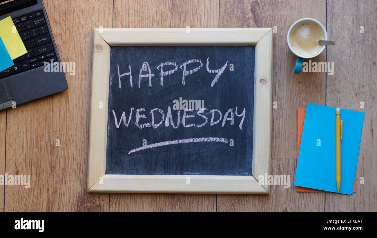 Happy wednesday written on a chalkboard at the office Stock Photo - Alamy