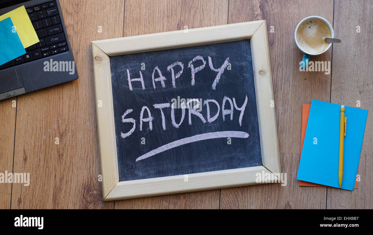 Happy saturday written on a chalkboard at the office Stock Photo - Alamy