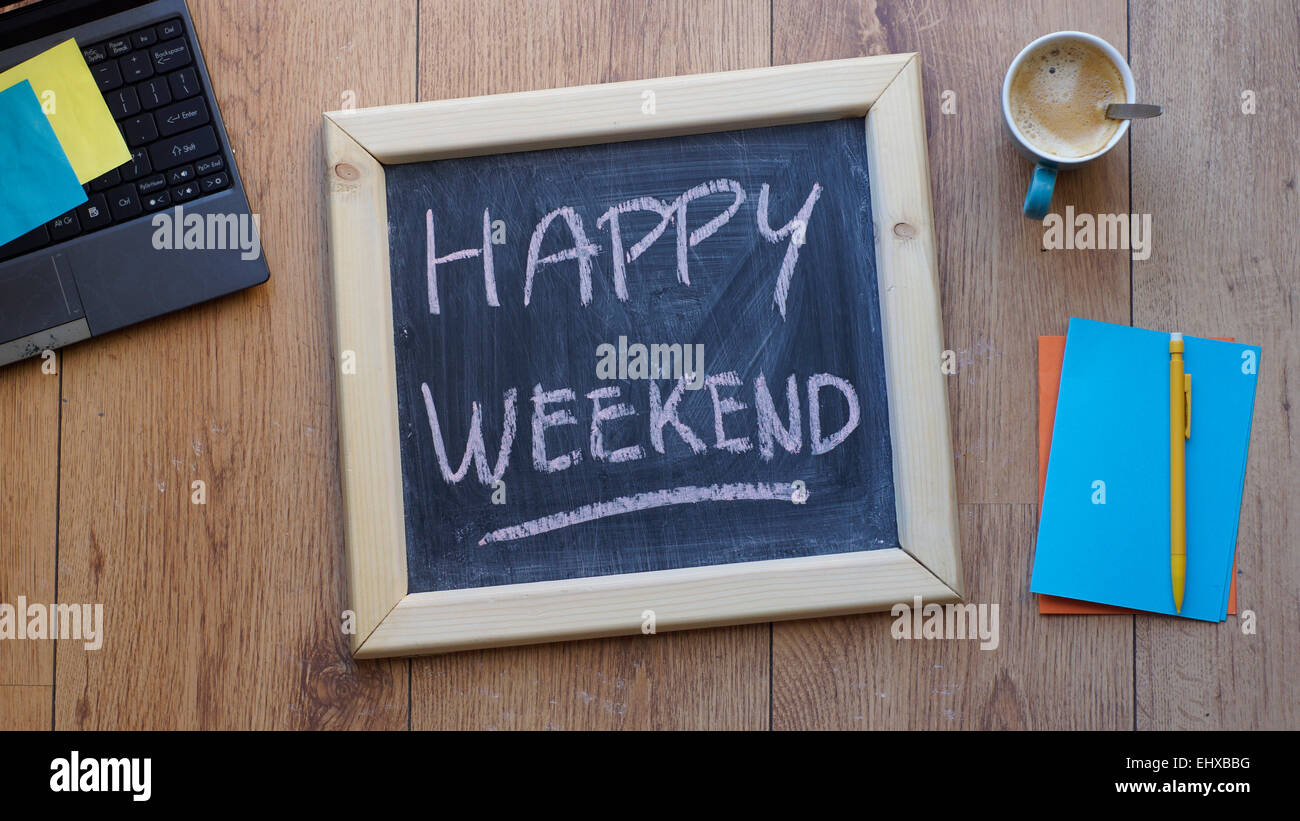 Happy weekend written on a chalkboard at the office Stock Photo - Alamy