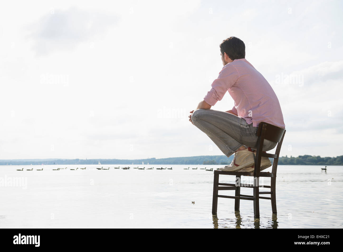Young man sitting chair lake alone thoughtful Stock Photo - Alamy