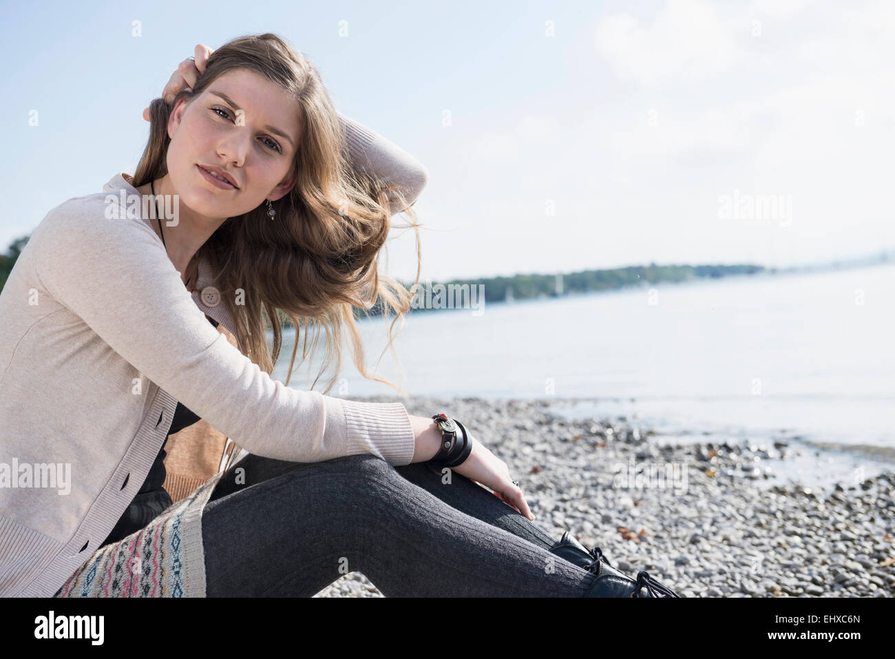 Portrait pretty young woman sitting lake shore Stock Photo - Alamy